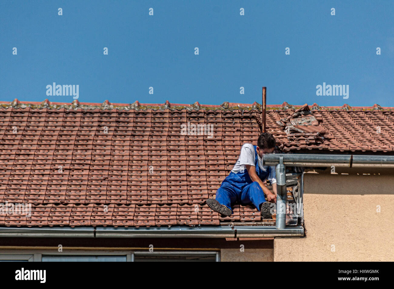 Man working. Construction worker on a roof. Real people Stock Photo - Alamy