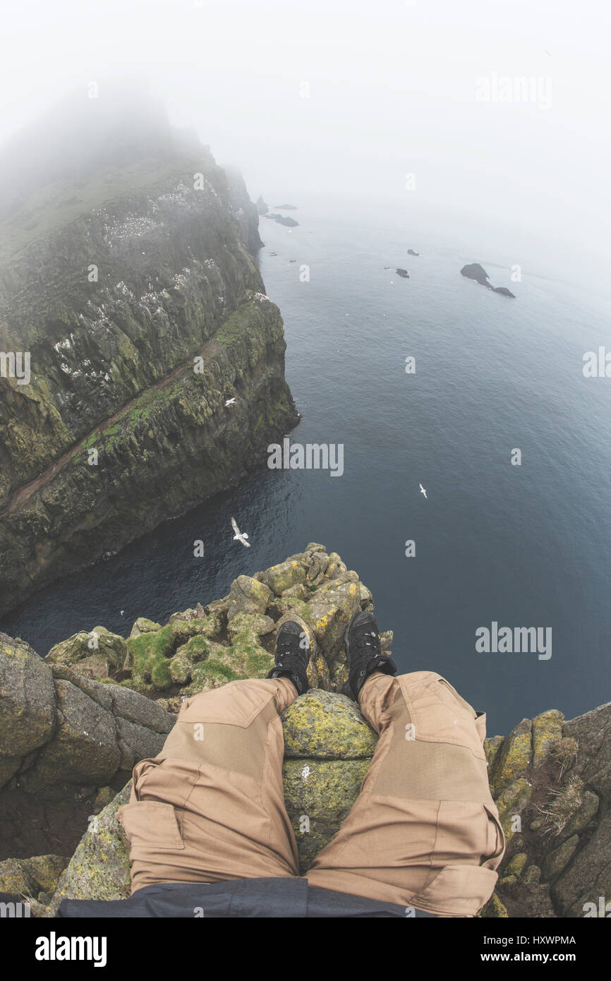 Man sitting on the edge of a cliff hi-res stock photography and images ...