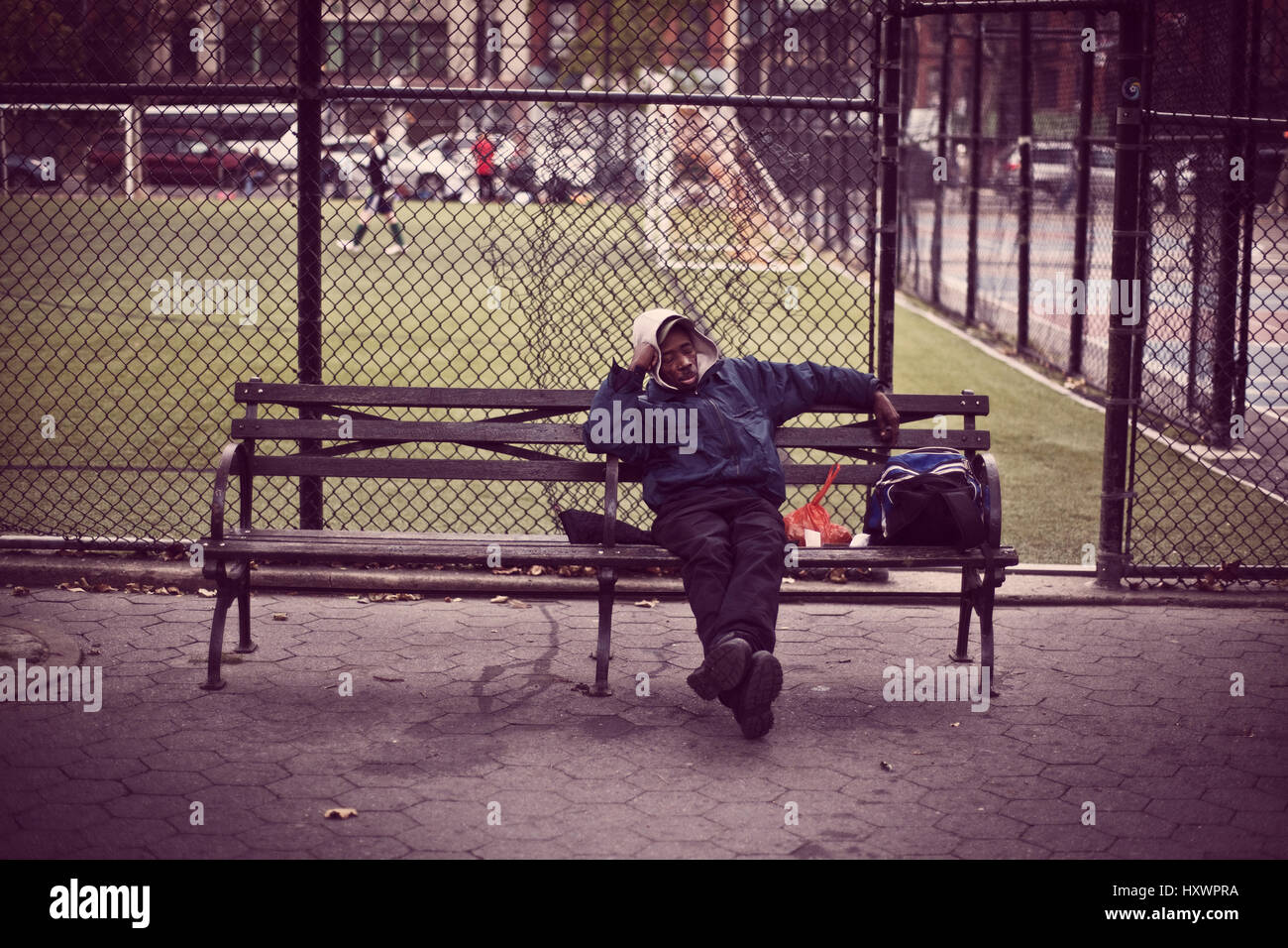A man is napping on a bench in the middle of New York City, United ...