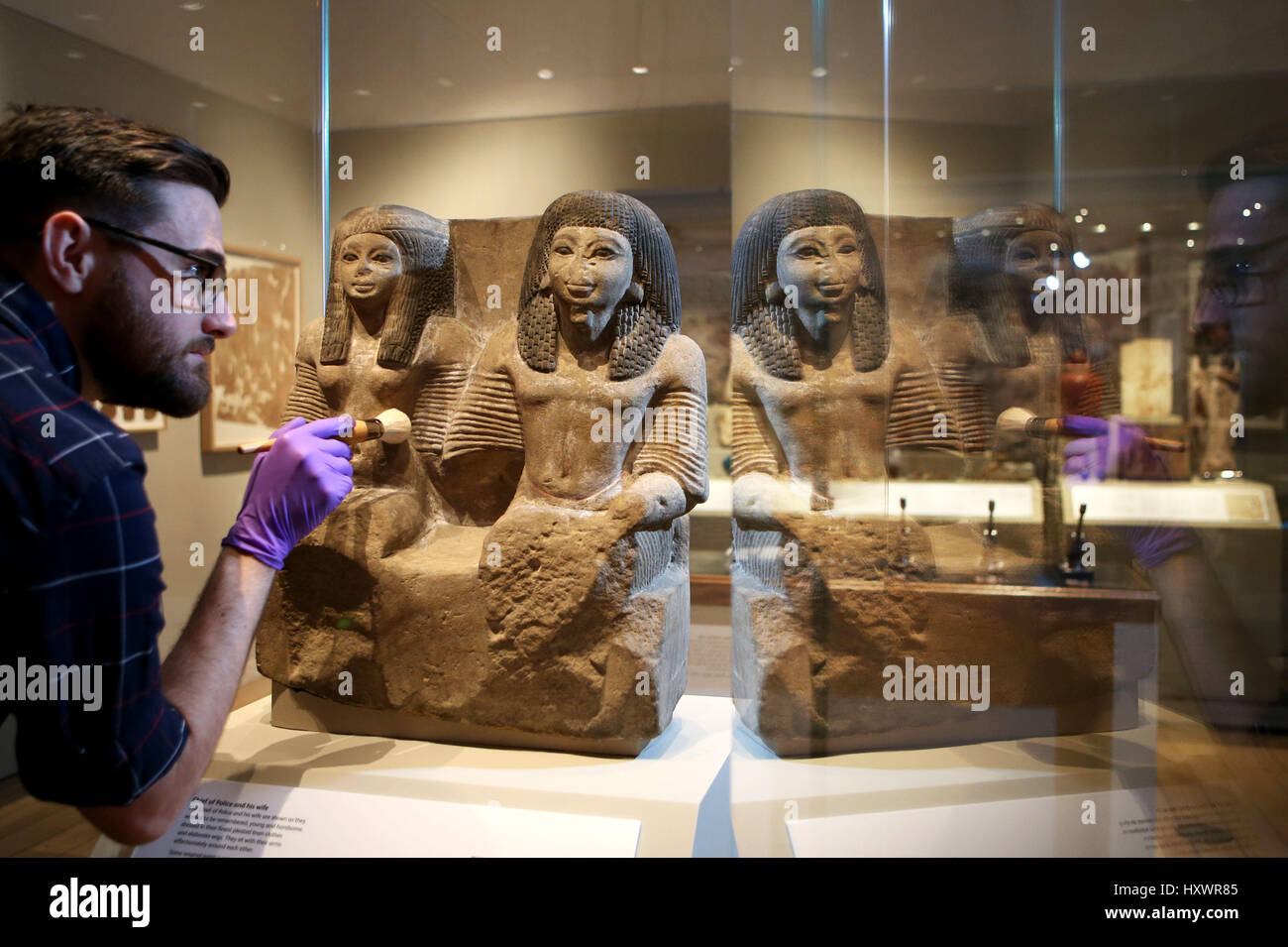 Assistant curator Dan Potter examines a sandstone statue which features ...