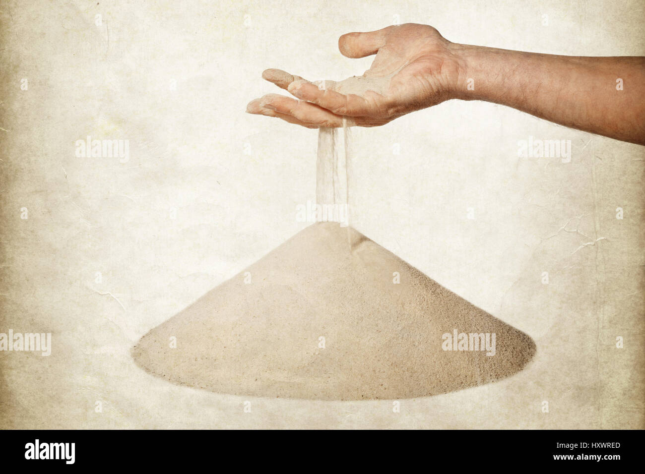 sand running through hand as a symbol for time running out. Cracked ...