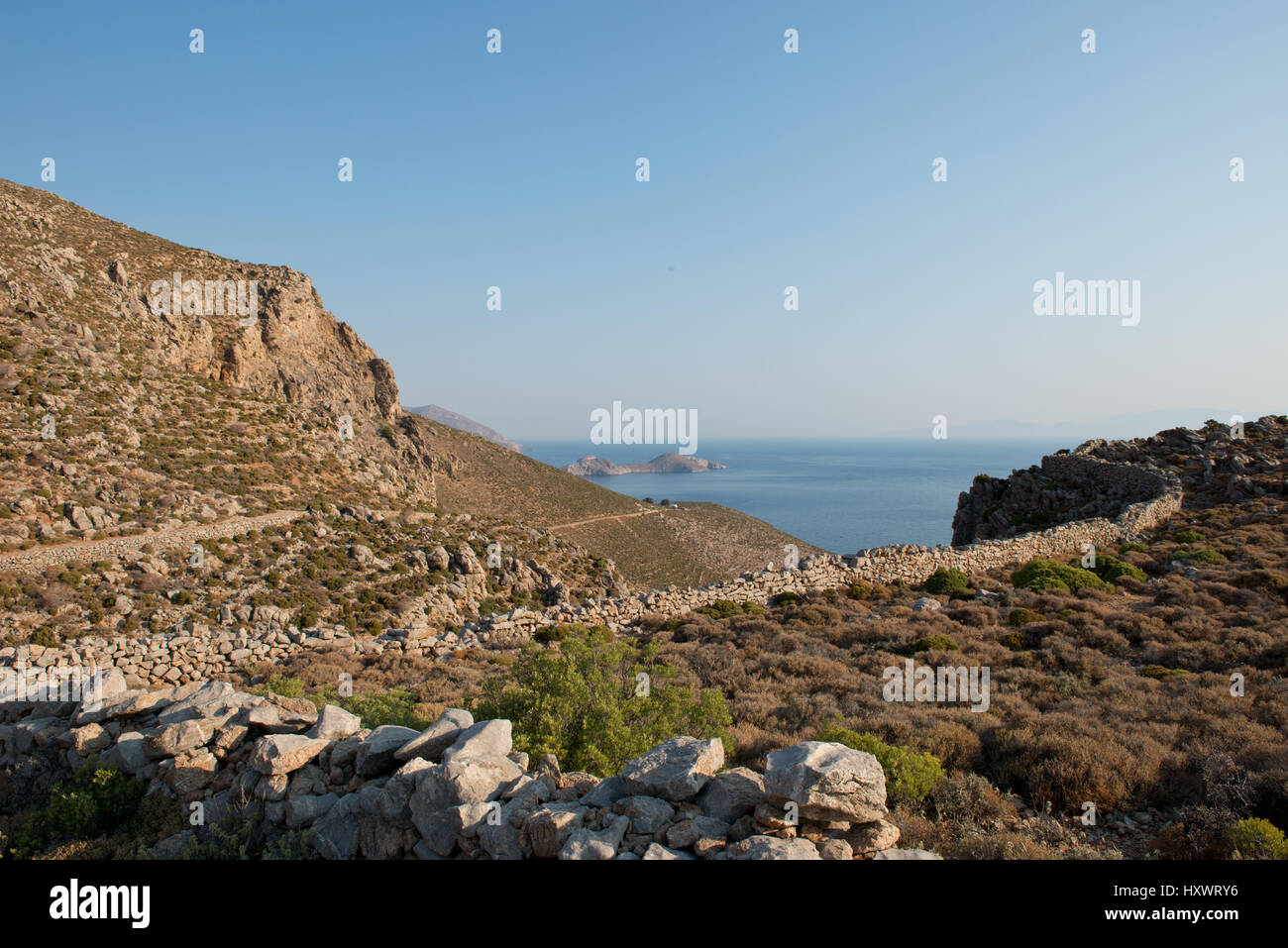 barren landscape with stone walls in the hills of Tilos hiking along a ...