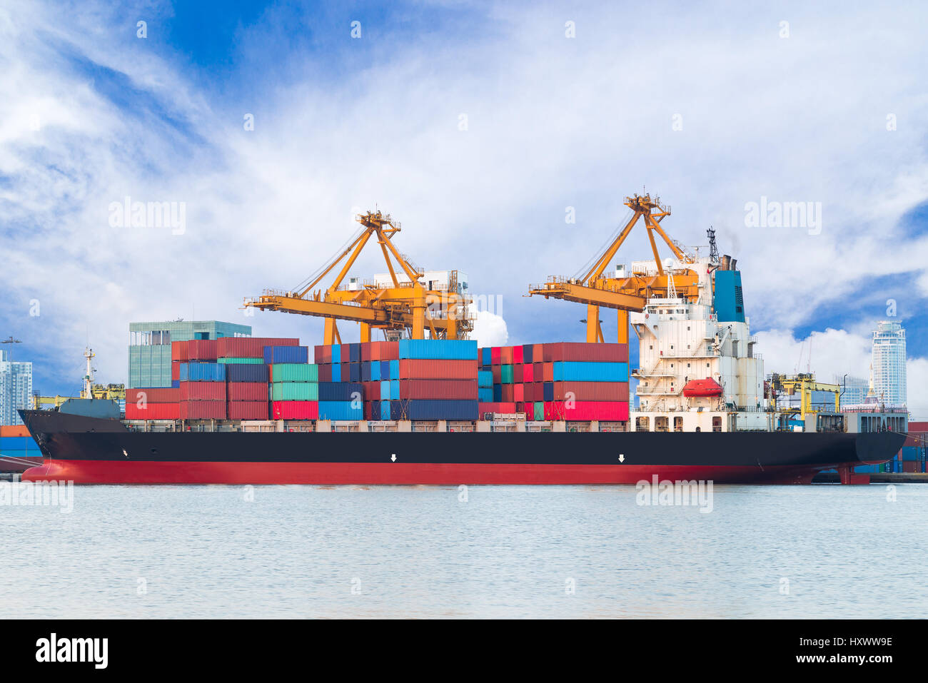 Container cargo freight ship with working crane loading bridge in ...