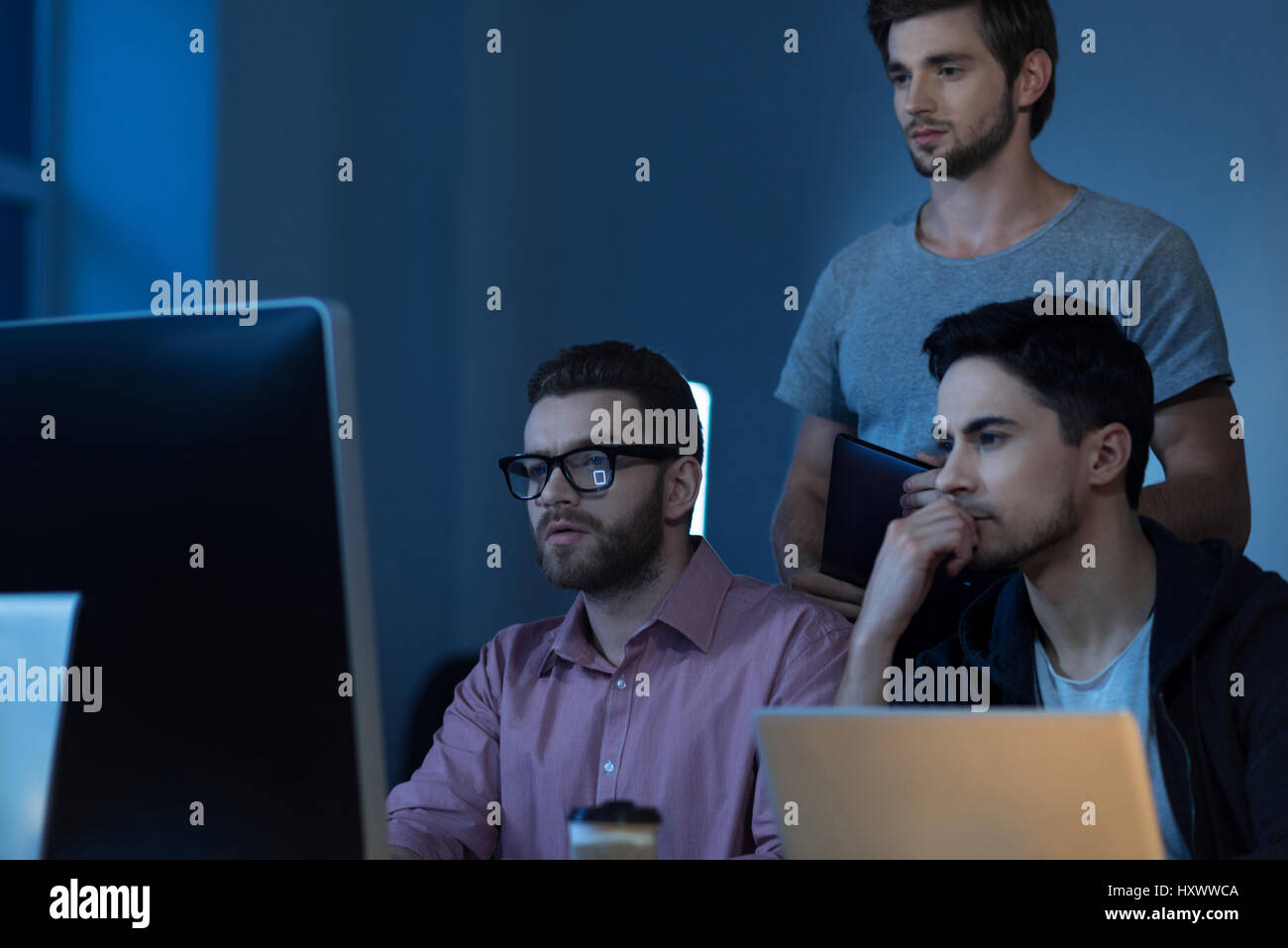 Handsome thoughtful programmers looking at the computer screen Stock ... Handsome thoughtful programmers looking at the computer screen Stock ...