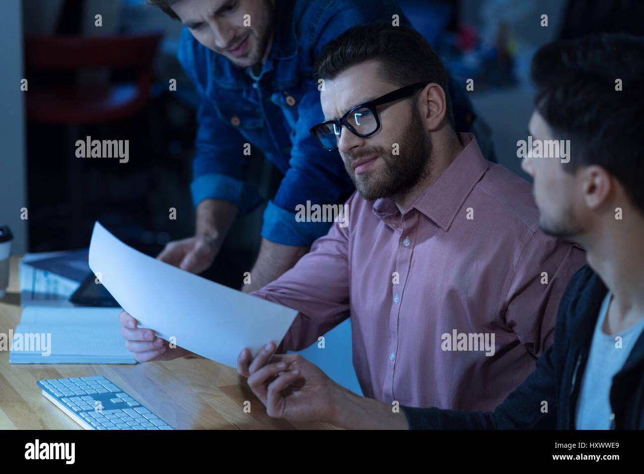 Serious good looking man holding a sheet of paper Stock Photo - Alamy