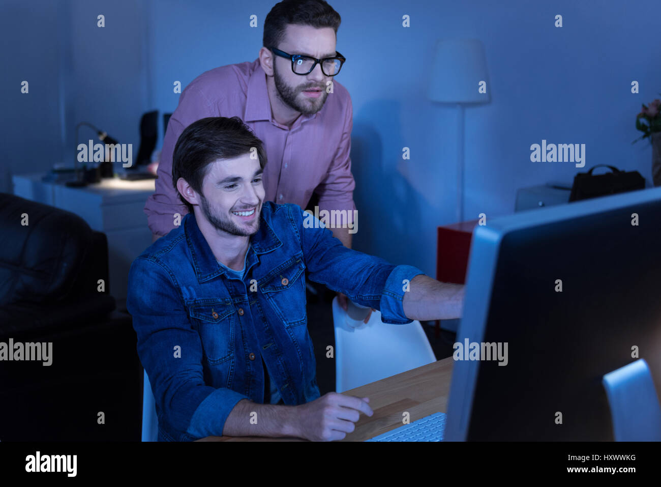 Cheerful delighted programmer smiling Stock Photo - Alamy