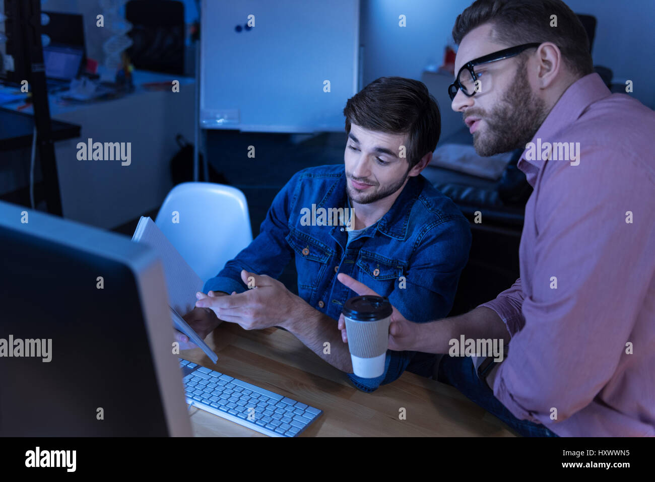 Nice handsome man showing his notes to a colleague Stock Photo - Alamy