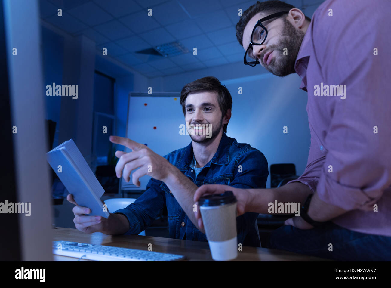 Joyful positive man pointing at the computer screen Stock Photo - Alamy