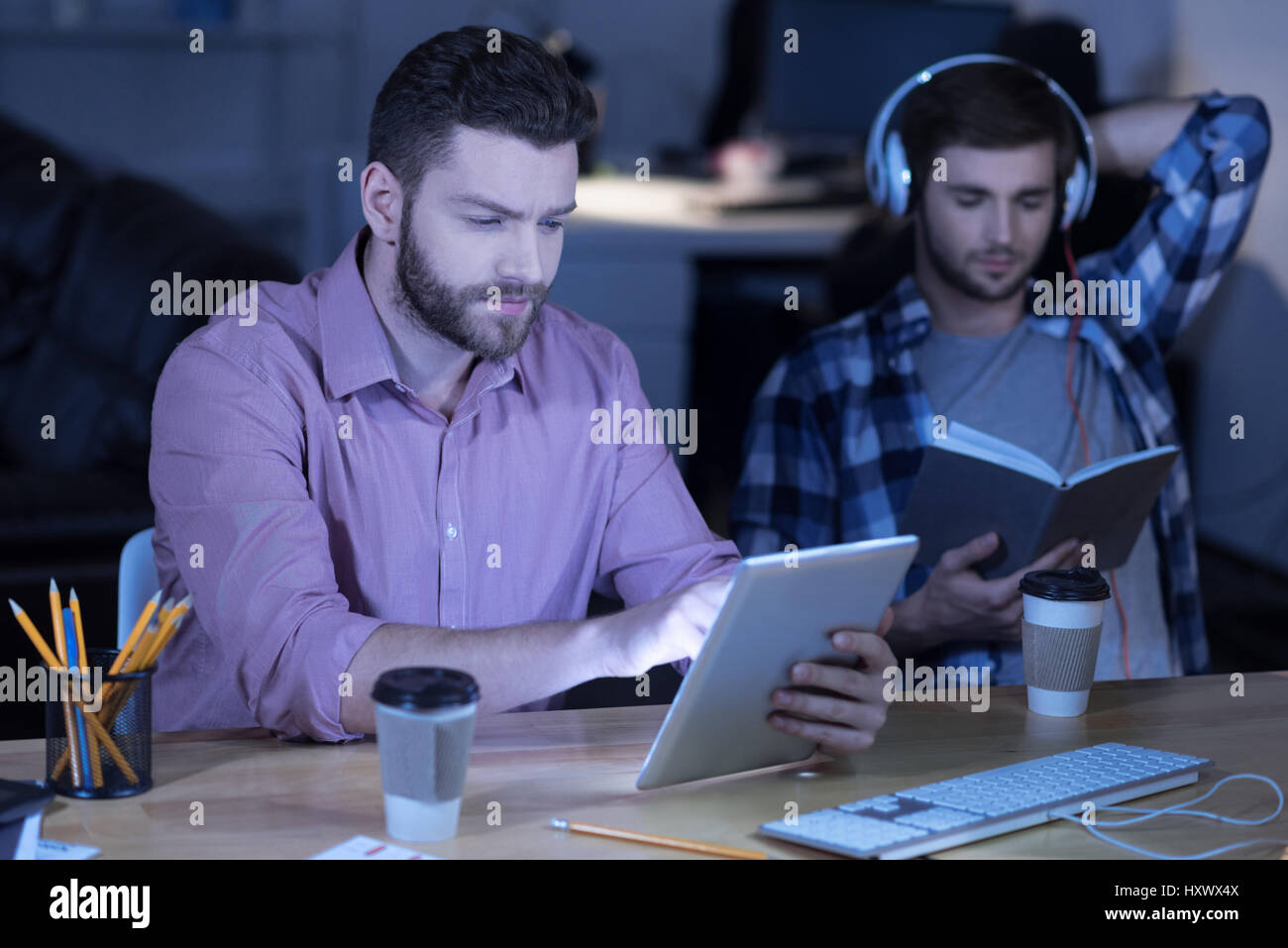 Serious handsome programmer working on a tablet Stock Photo - Alamy