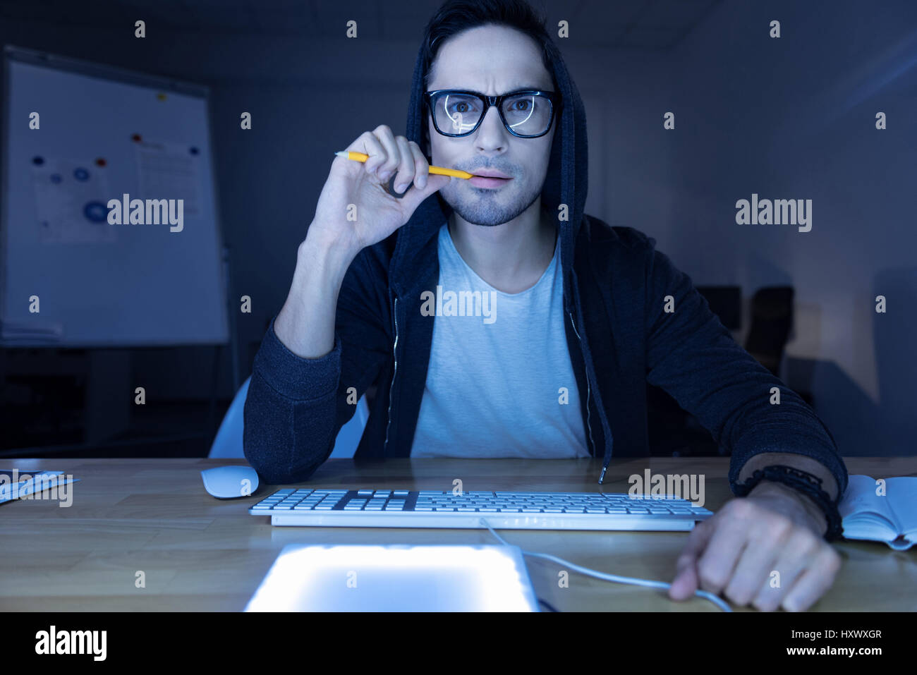 Handsome genius hacker biting a pencil Stock Photo - Alamy