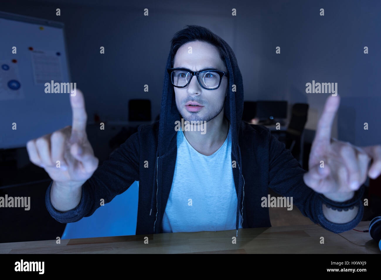 Nice pleasant man looking at his fingers Stock Photo - Alamy