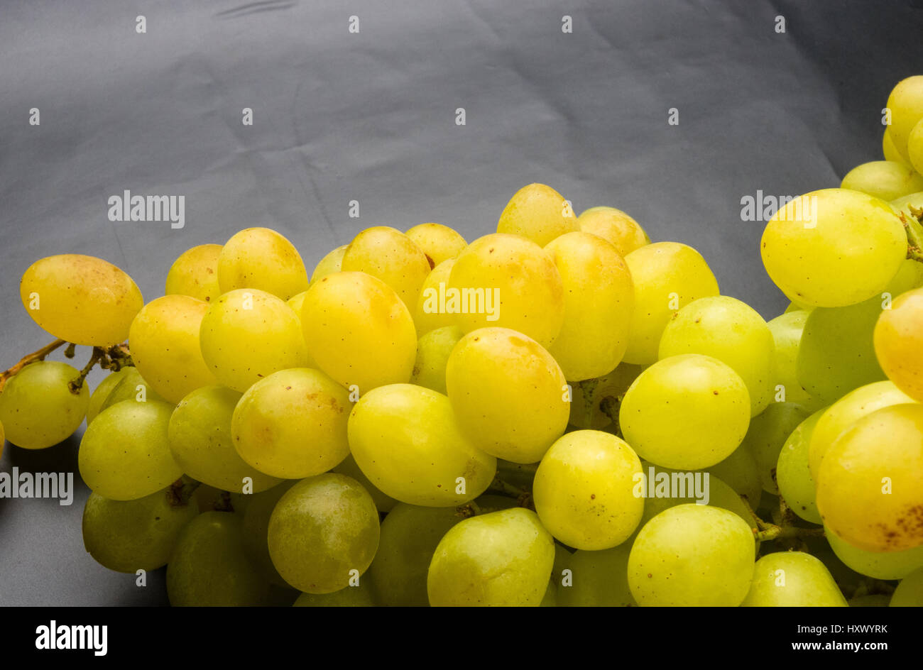 Large grapes cluster amber color on black background Stock Photo - Alamy