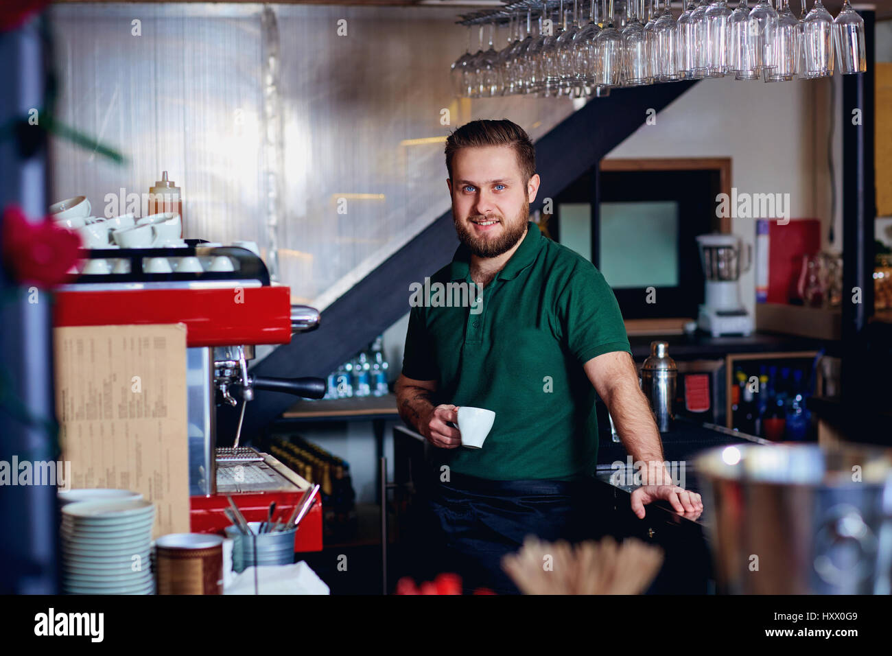 Bartender barista with coffee in hand behind the bar Stock Photo - Alamy
