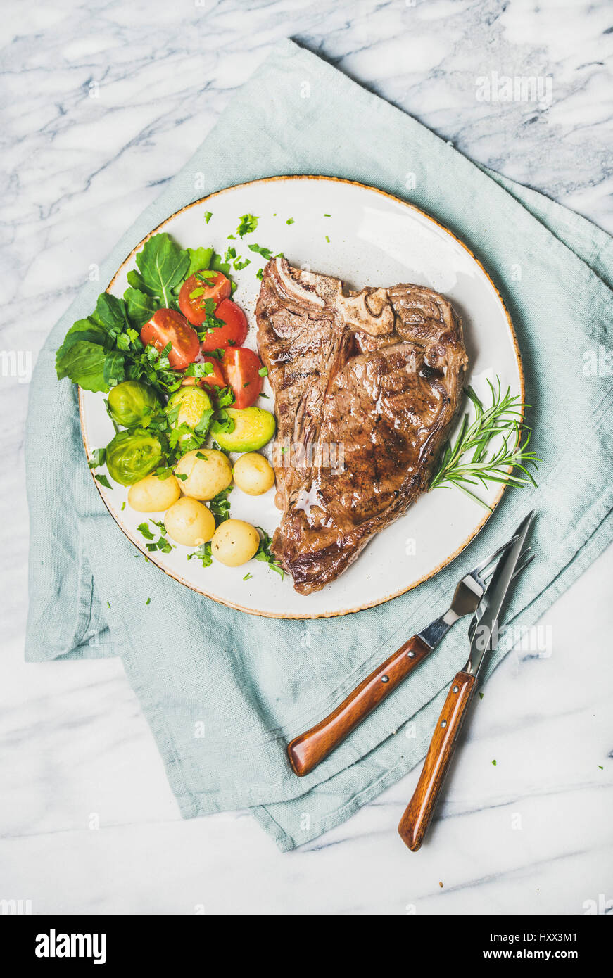 Grilled meat dinner plate. Cooked beef tbone steak with vegetables and ...