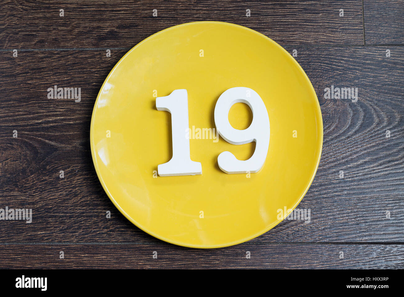 Figure nineteen on the yellow plate and brown background Stock Photo ...