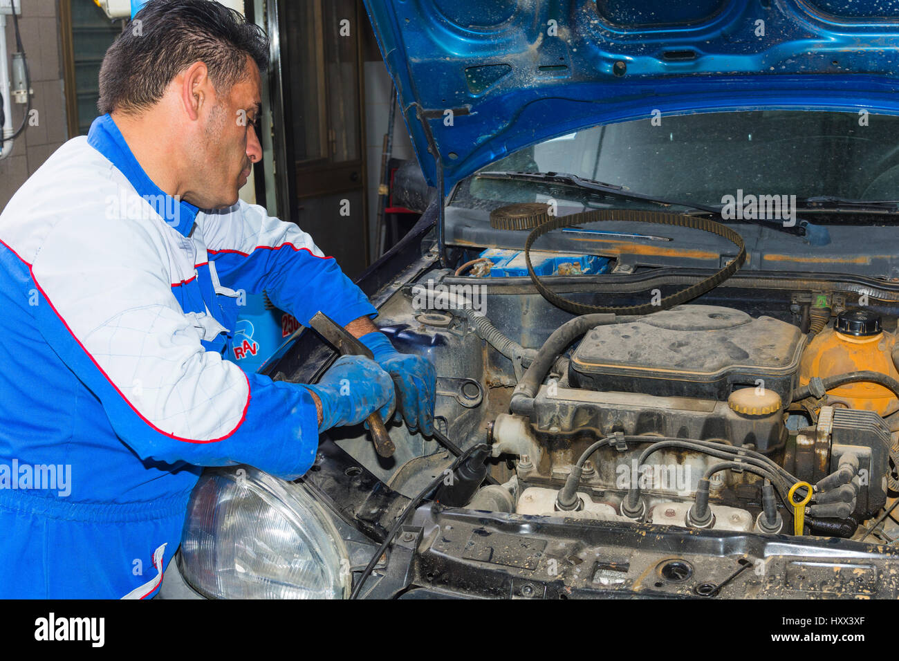 Car mechanic fixing an engine in his garage. copy space Stock Photo - Alamy