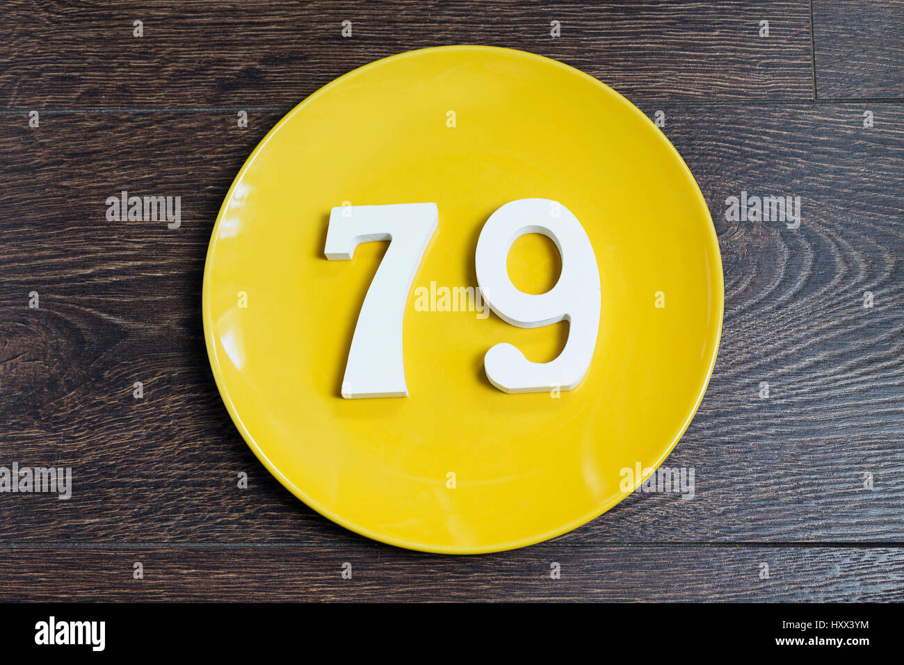 The number seventy-nine on the yellow plate and brown background Stock ...