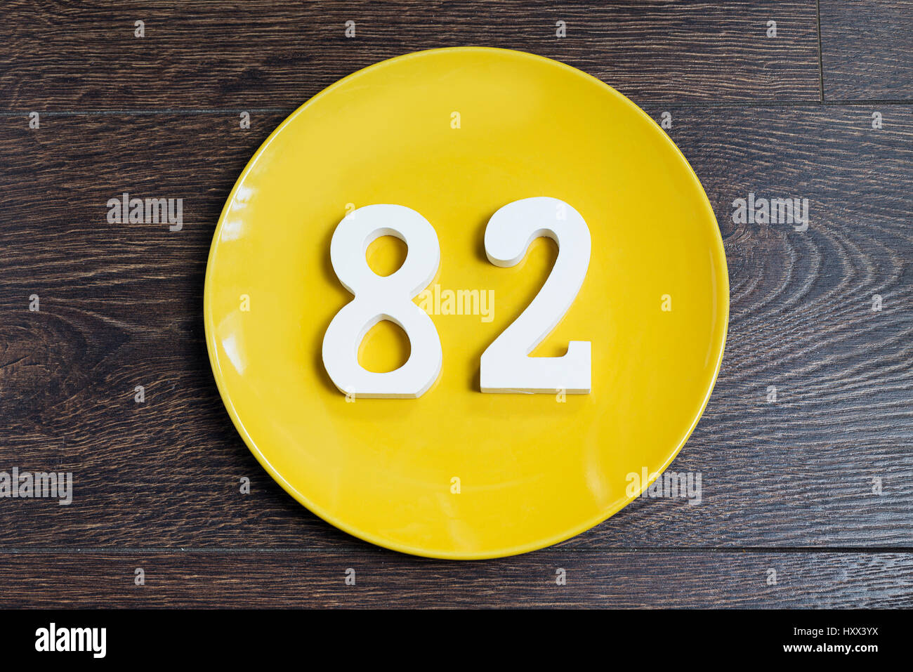 The number eighty-two on the yellow plate and brown background Stock ...