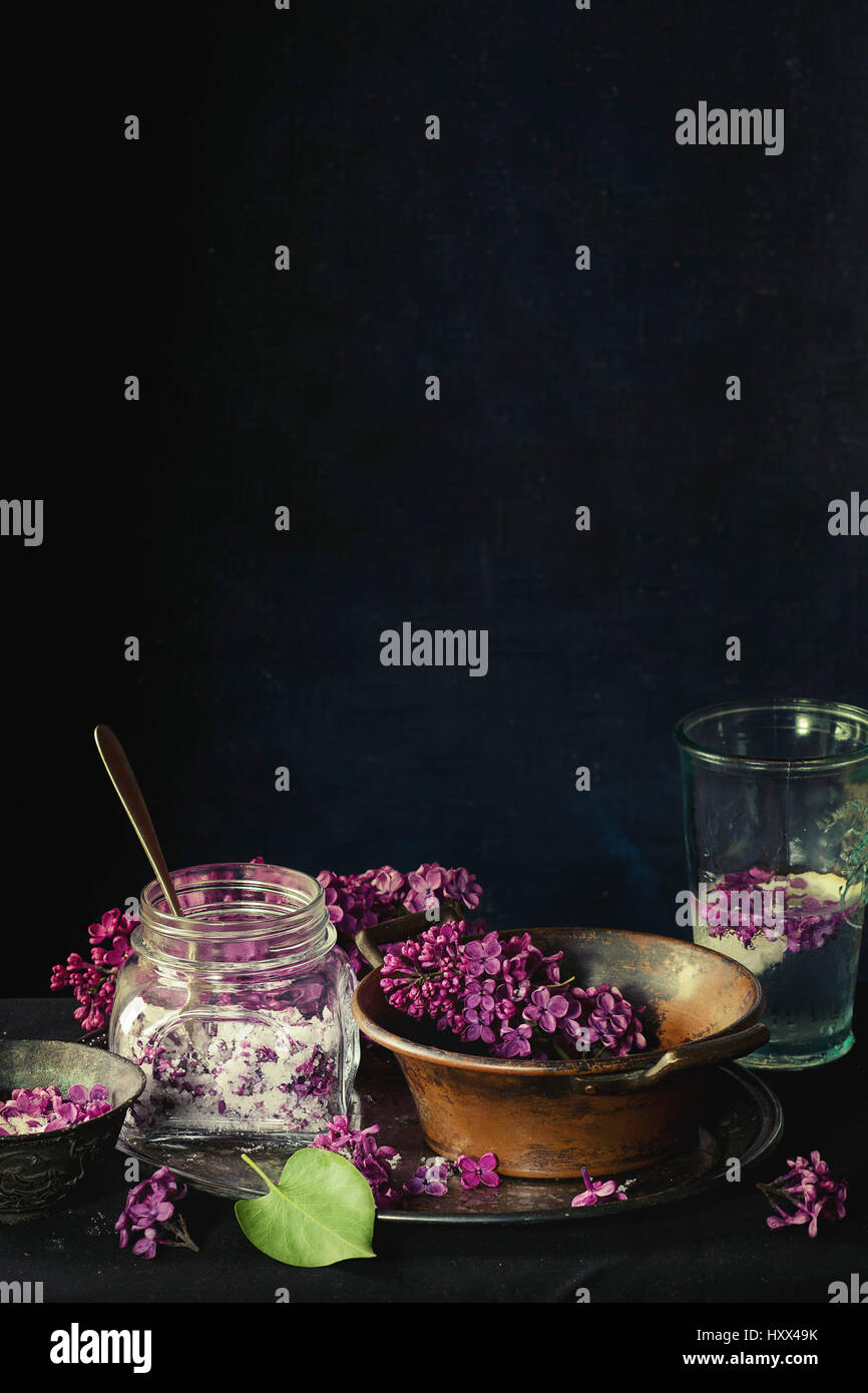 Glass jar of lilac flowers in sugar, glass of lilac water with lemon ...