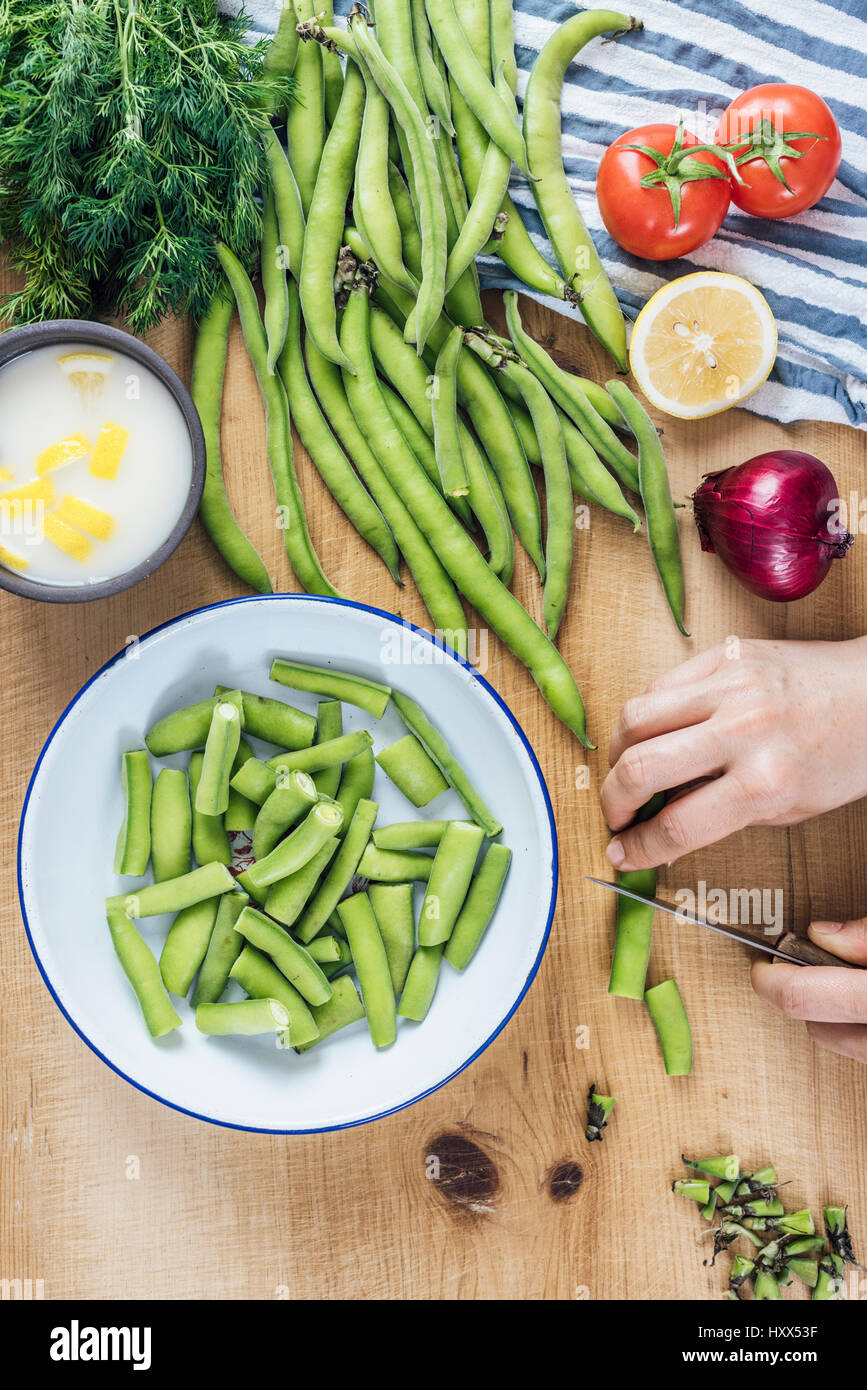 A woman chopping fresh fava beans to make Mediterranean style fava ...