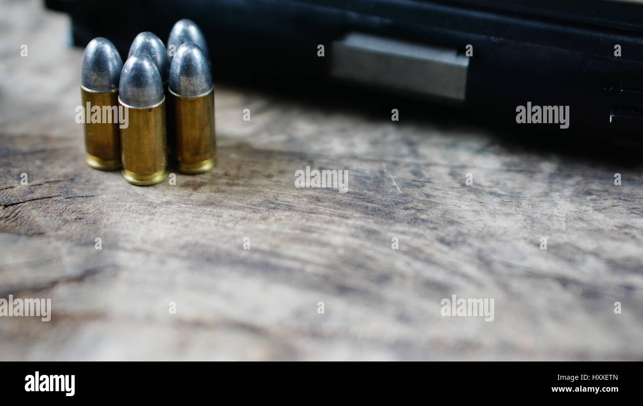 Bullets and a firearm on the wood. Bullets are a projectile expelled ...