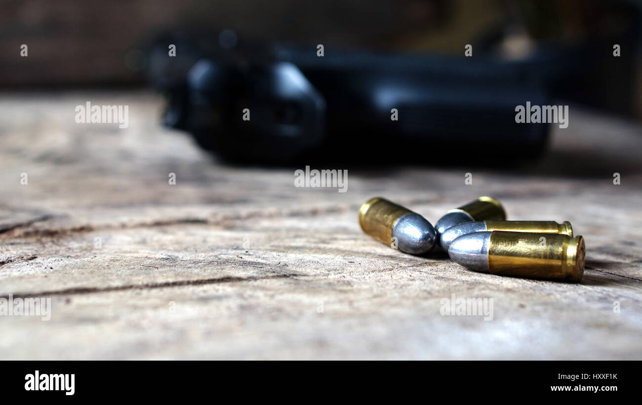 Bullets and a firearm on the wood. Bullets are a projectile expelled ...