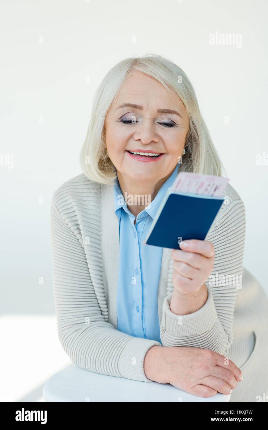 Portrait Of Smiling Senior Woman Looking At Passports And Tickets