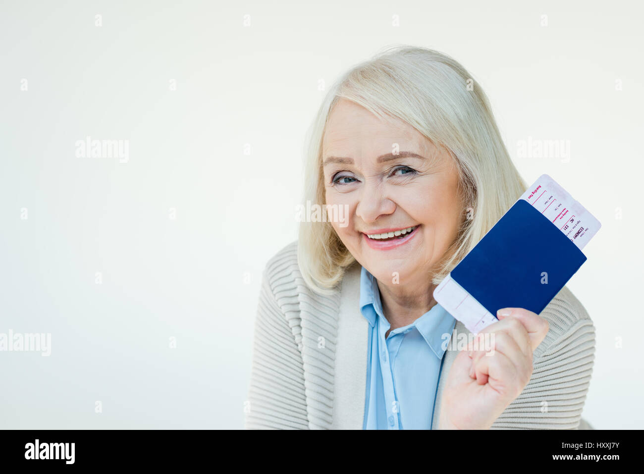 Portrait Of Smiling Senior Woman Showing Passports And Tickets
