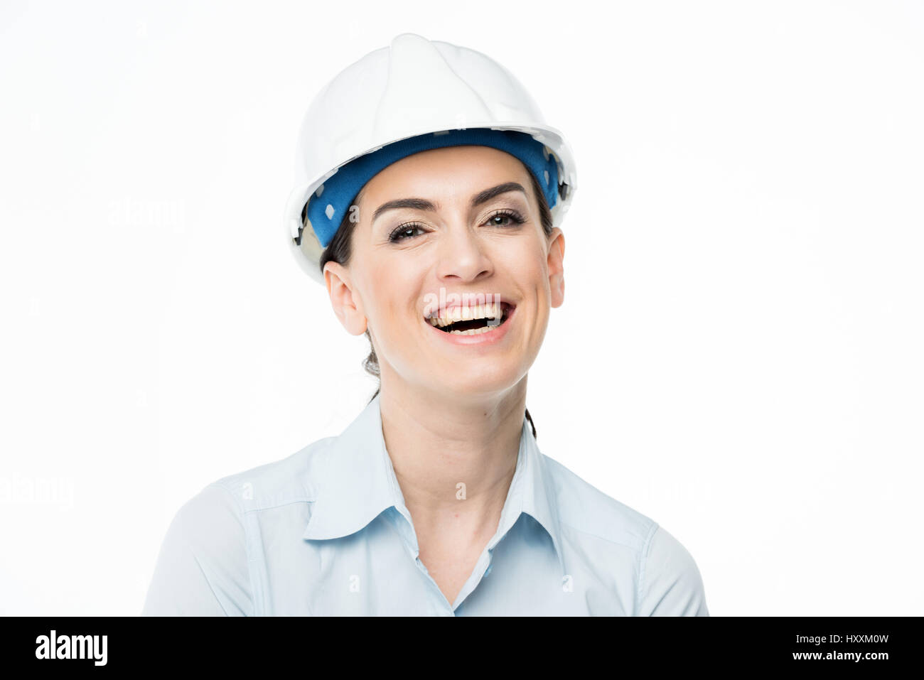Female architect in hard hat laughing and looking at camera on white ...