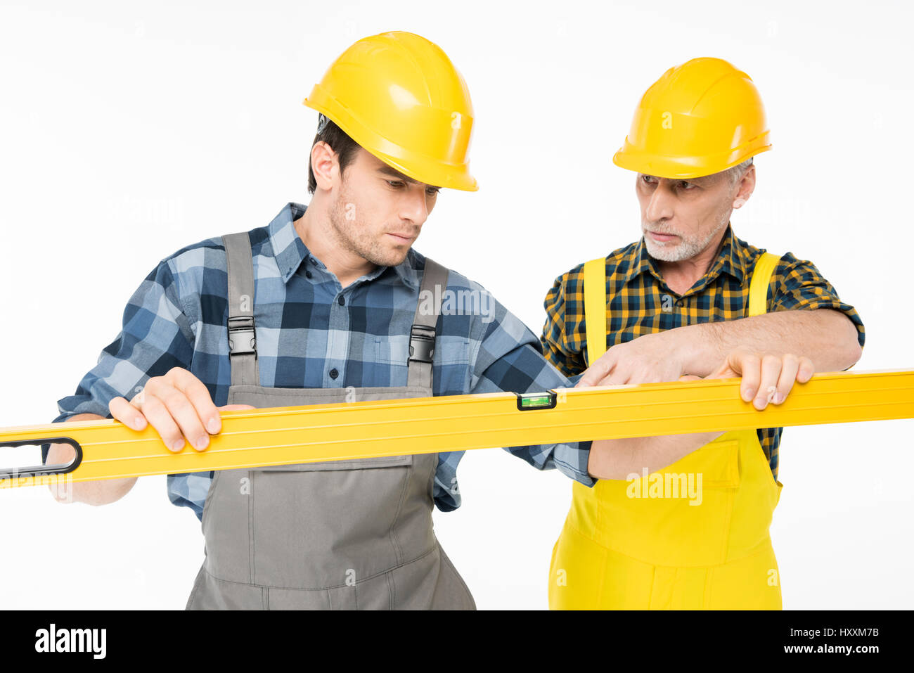 Two serious workmen working with level tool on white Stock Photo - Alamy