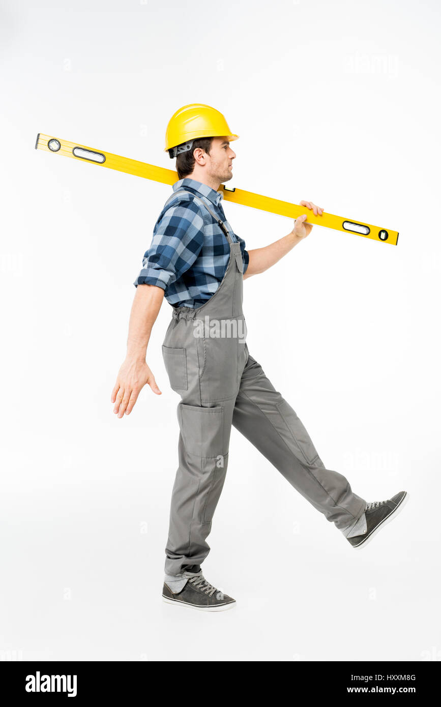 Side view of workman with level tool walking on white Stock Photo - Alamy