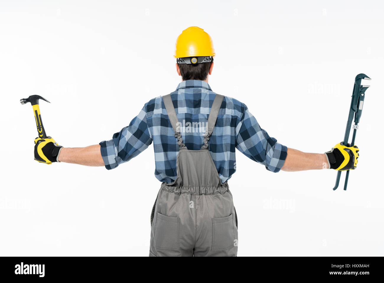 Back view of workman holding hammer and pipe wrench on white Stock ...