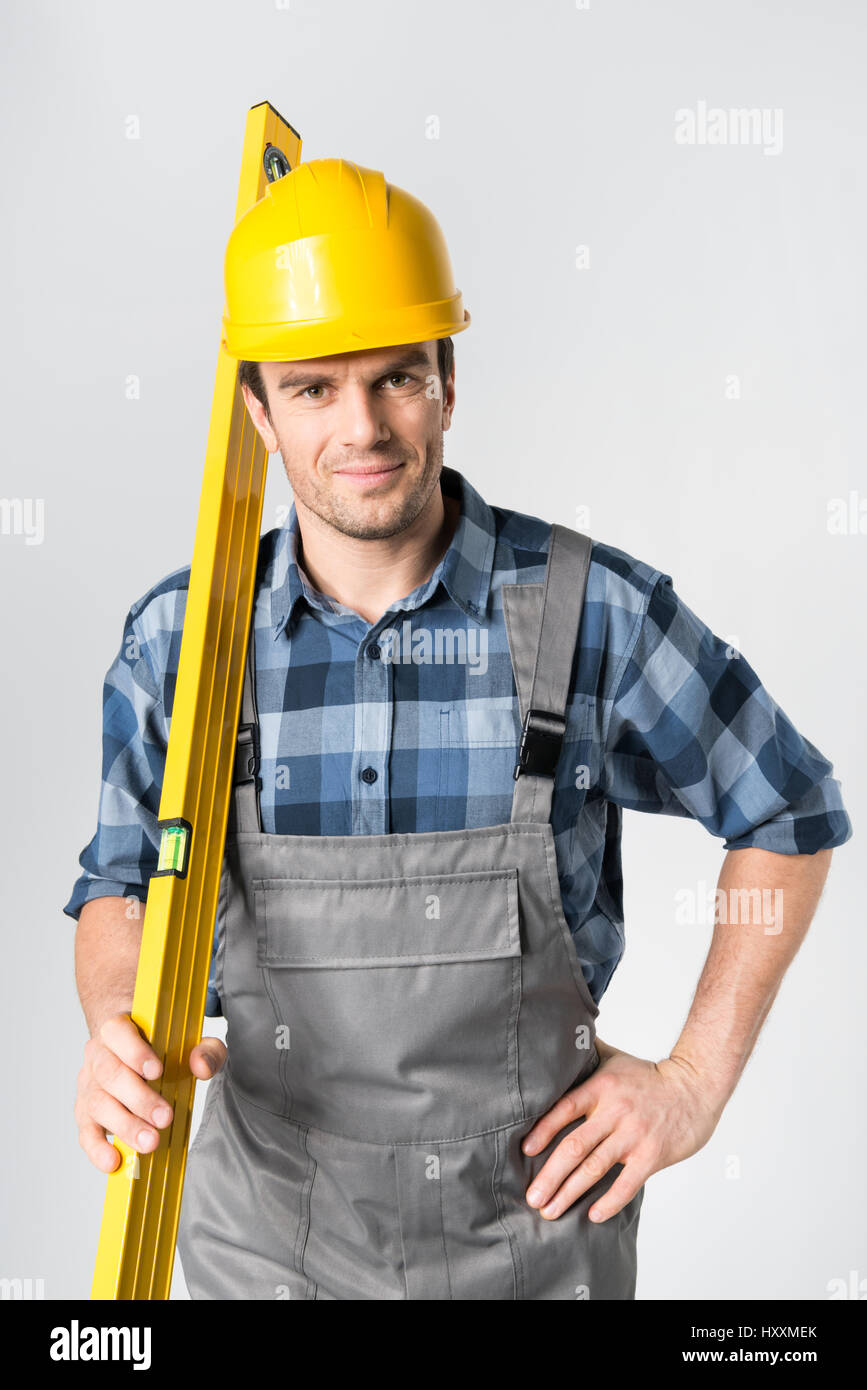 Professional workman with level tool smiling at camera Stock Photo - Alamy
