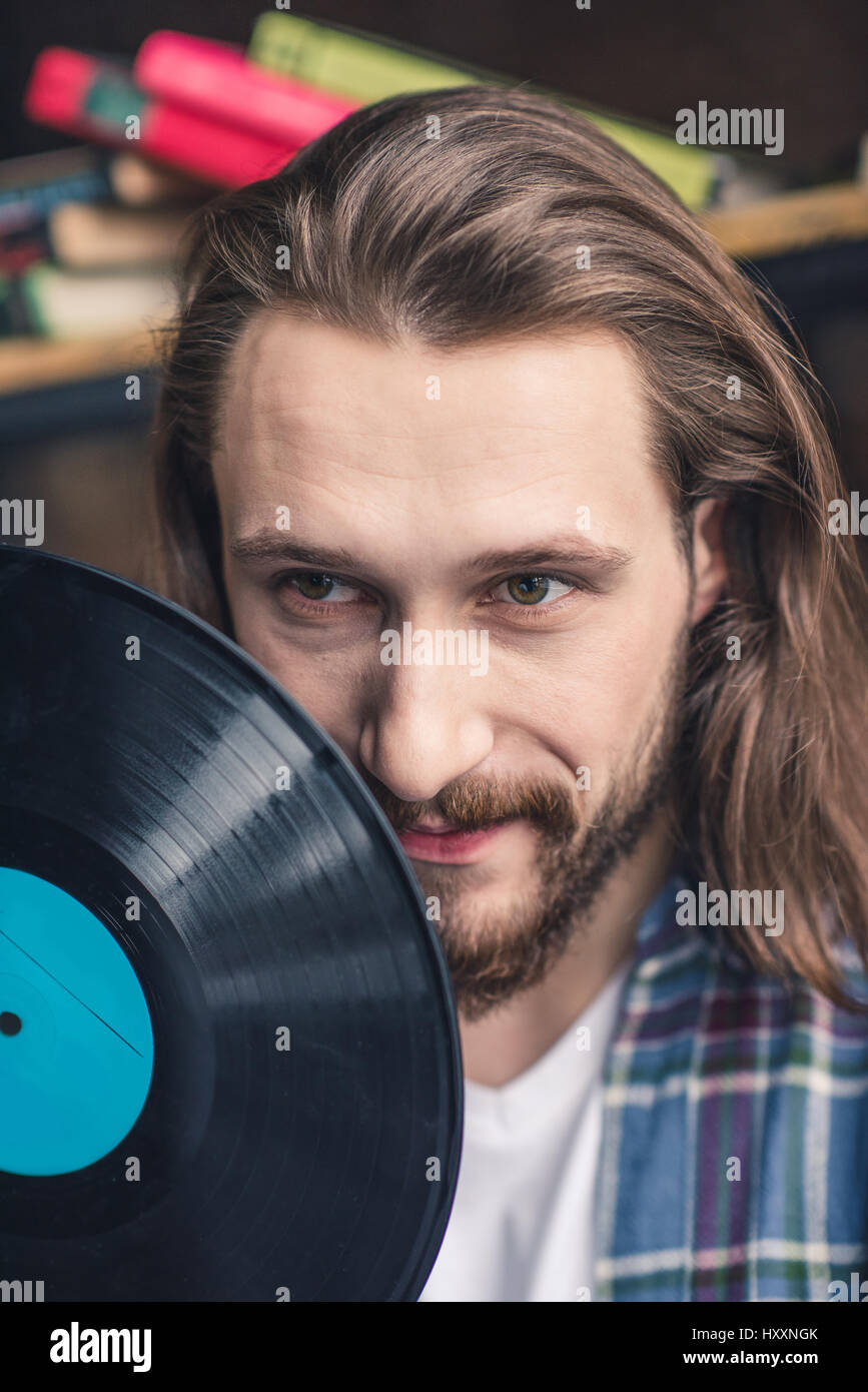Young smiling bearded man holding vinyl record Stock Photo - Alamy