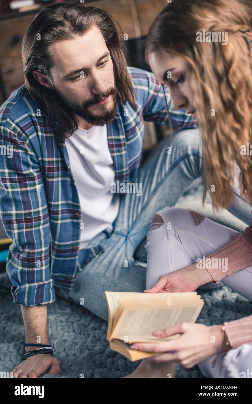 Attractive young couple reading book together Stock Photo - Alamy