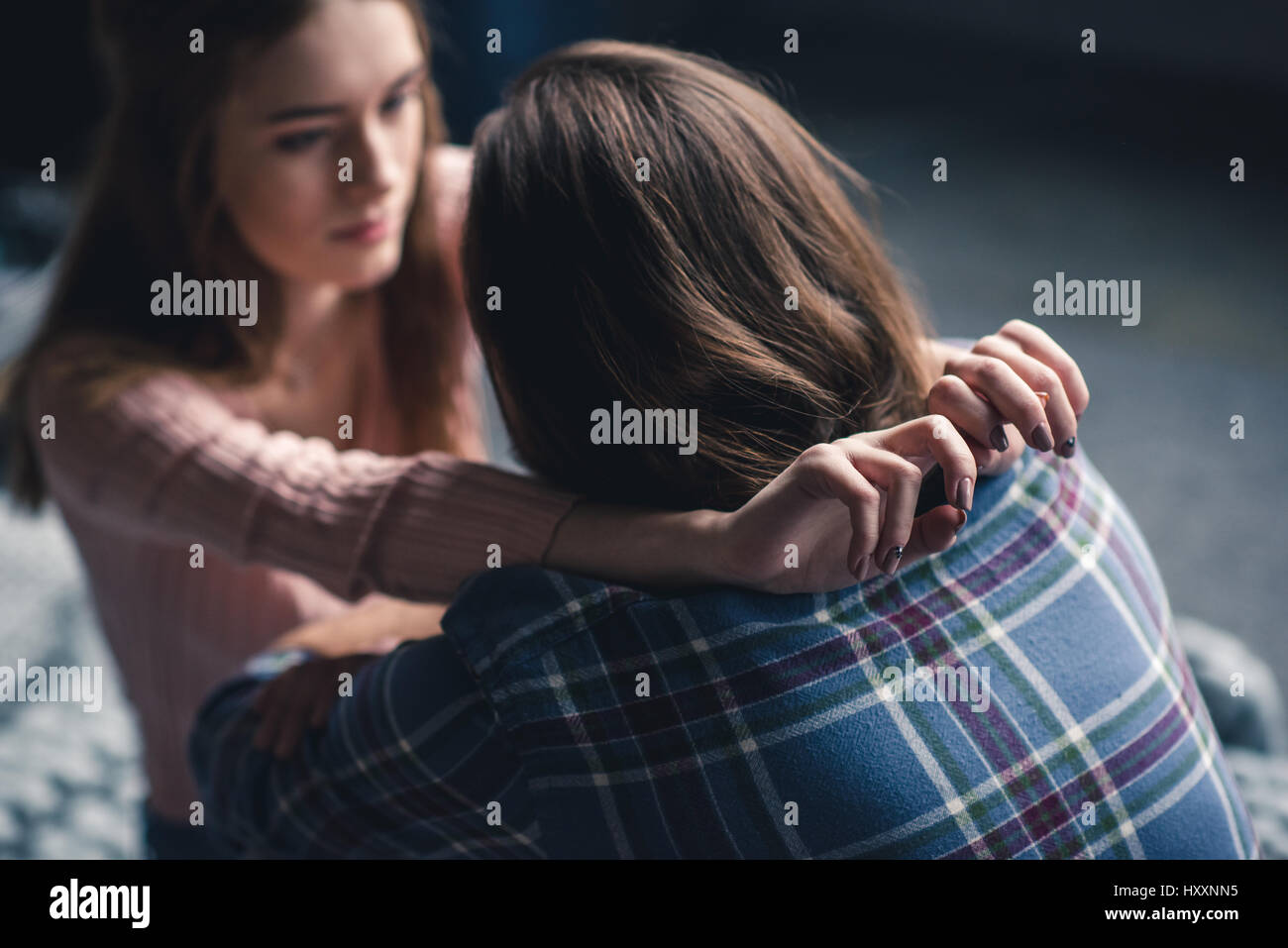 Attractive young couple sitting and hugging at home Stock Photo - Alamy