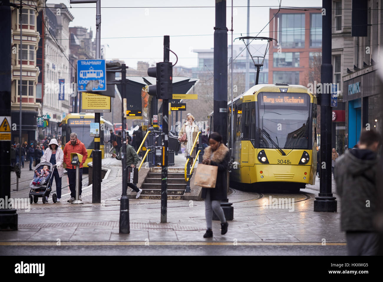A yellow Metrolink tram on Market Street Manchester city centre ...