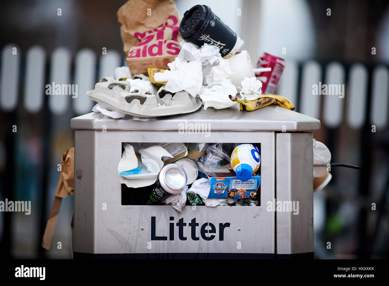 Litter bin overflowing onto the pavement and street at Stockport town ...