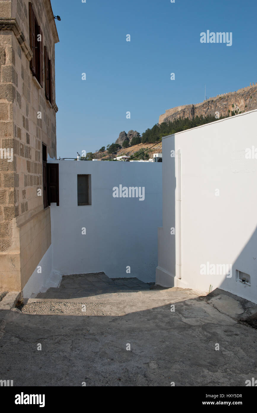 narrow street with ancient house, white walls and steps and a view to ...