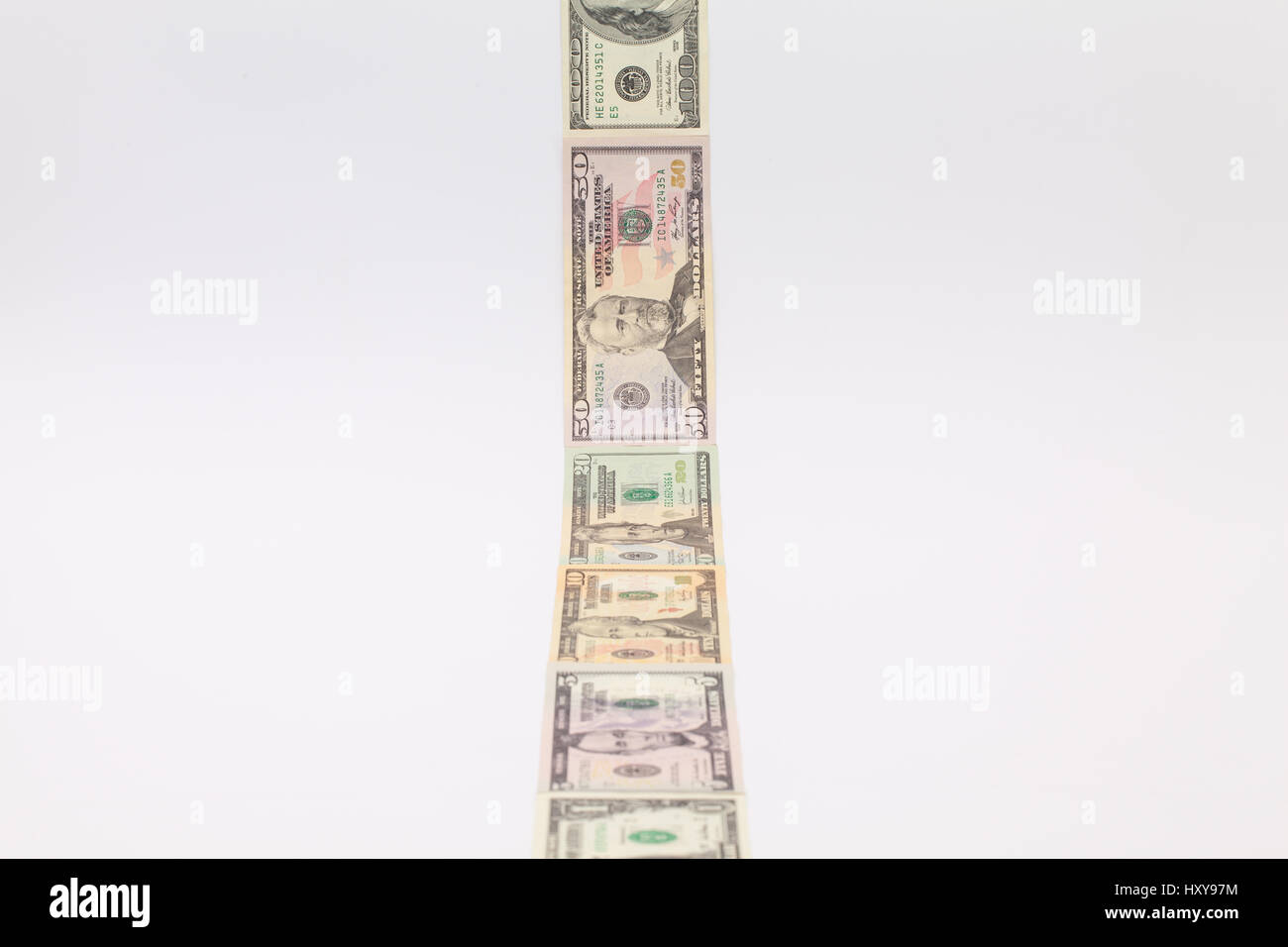 Strip of different us dollar banknotes on the white table Stock Photo ...