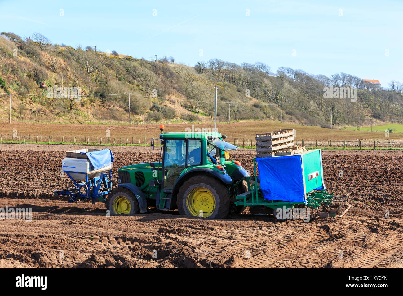 Planting potatoes using a tractor and farm hands, Ayrshire, Scotland ...