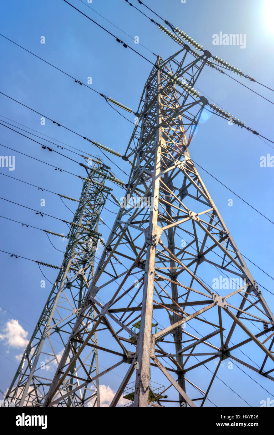 High voltage electrical overhead lines on blue sky Stock Photo - Alamy