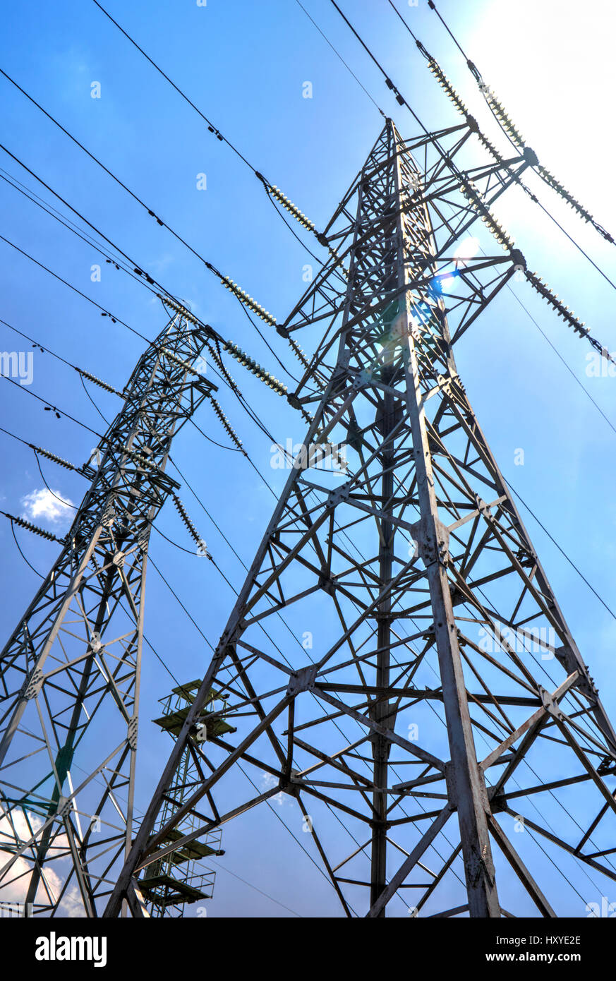 High voltage electrical overhead lines on blue sky Stock Photo - Alamy