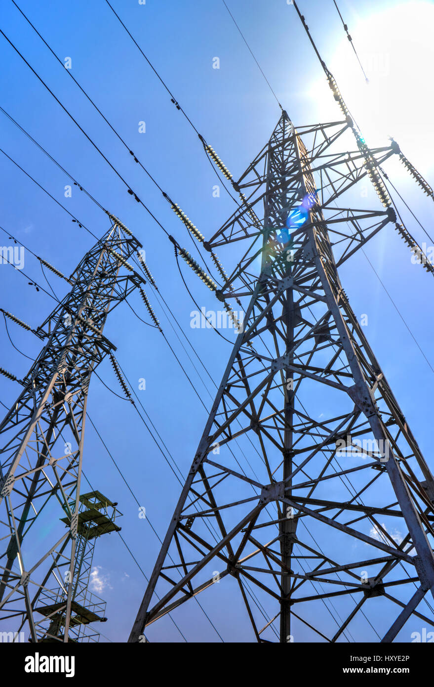 High voltage electrical overhead lines on blue sky Stock Photo - Alamy