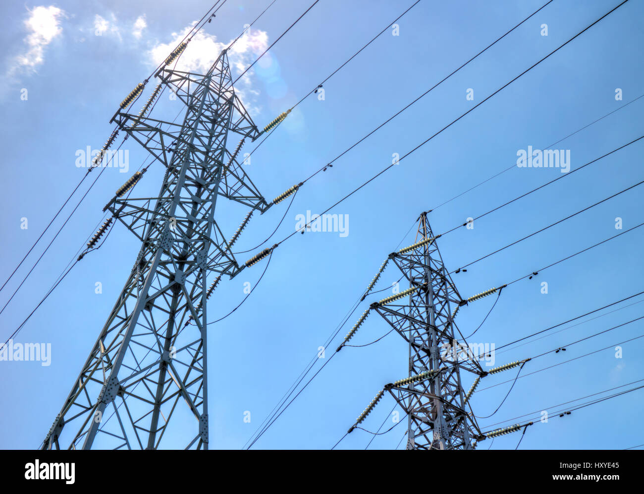 High voltage electrical overhead lines on blue sky Stock Photo - Alamy