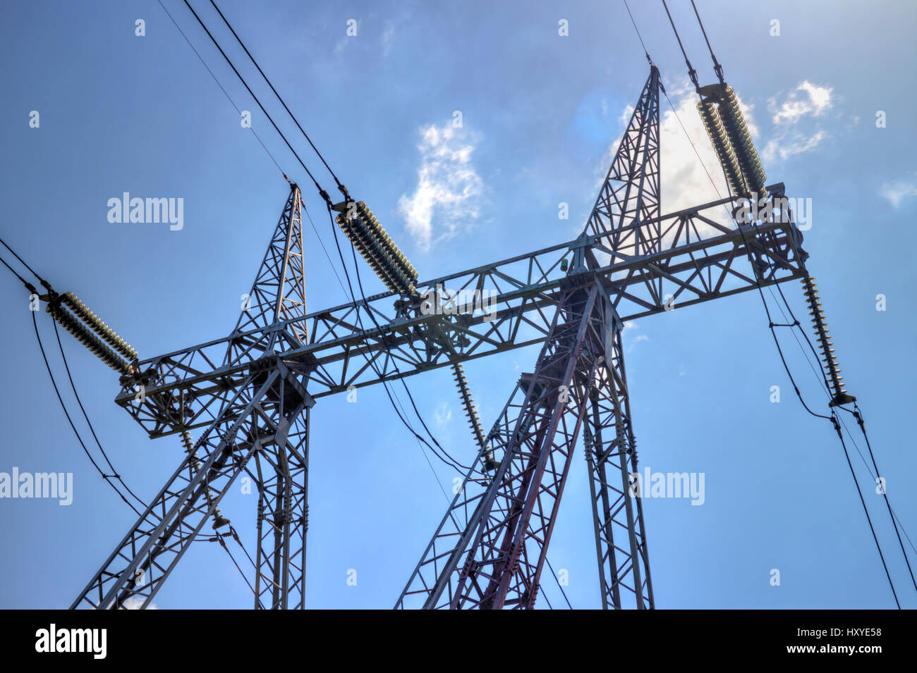 High voltage electrical overhead lines on blue sky Stock Photo - Alamy