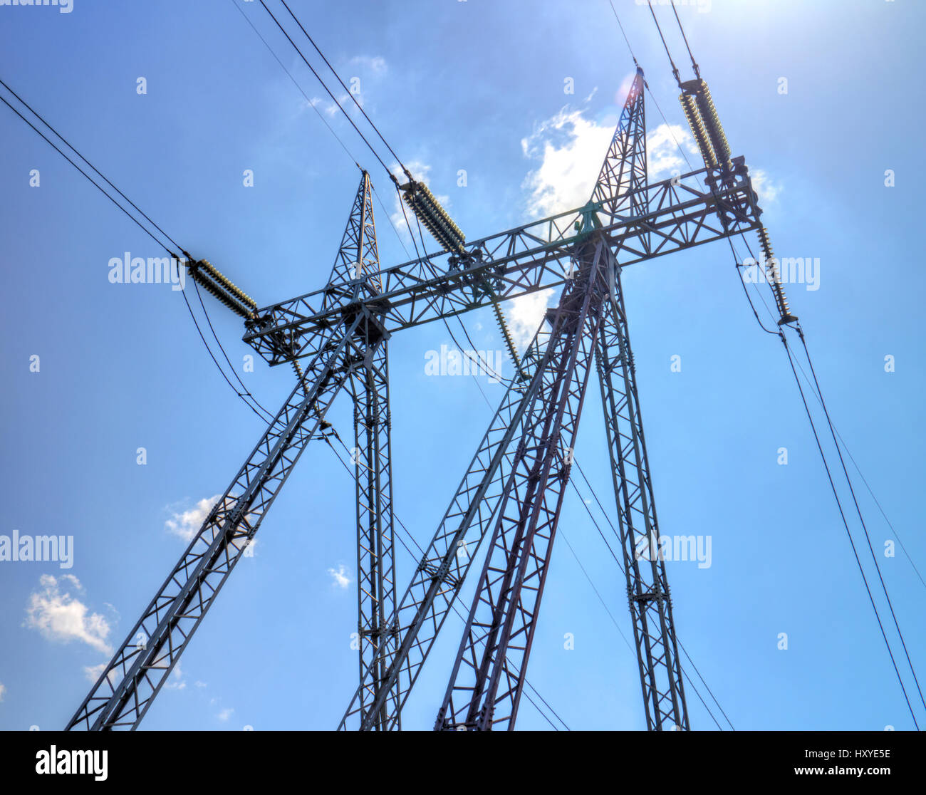 High voltage electrical overhead lines on blue sky Stock Photo - Alamy