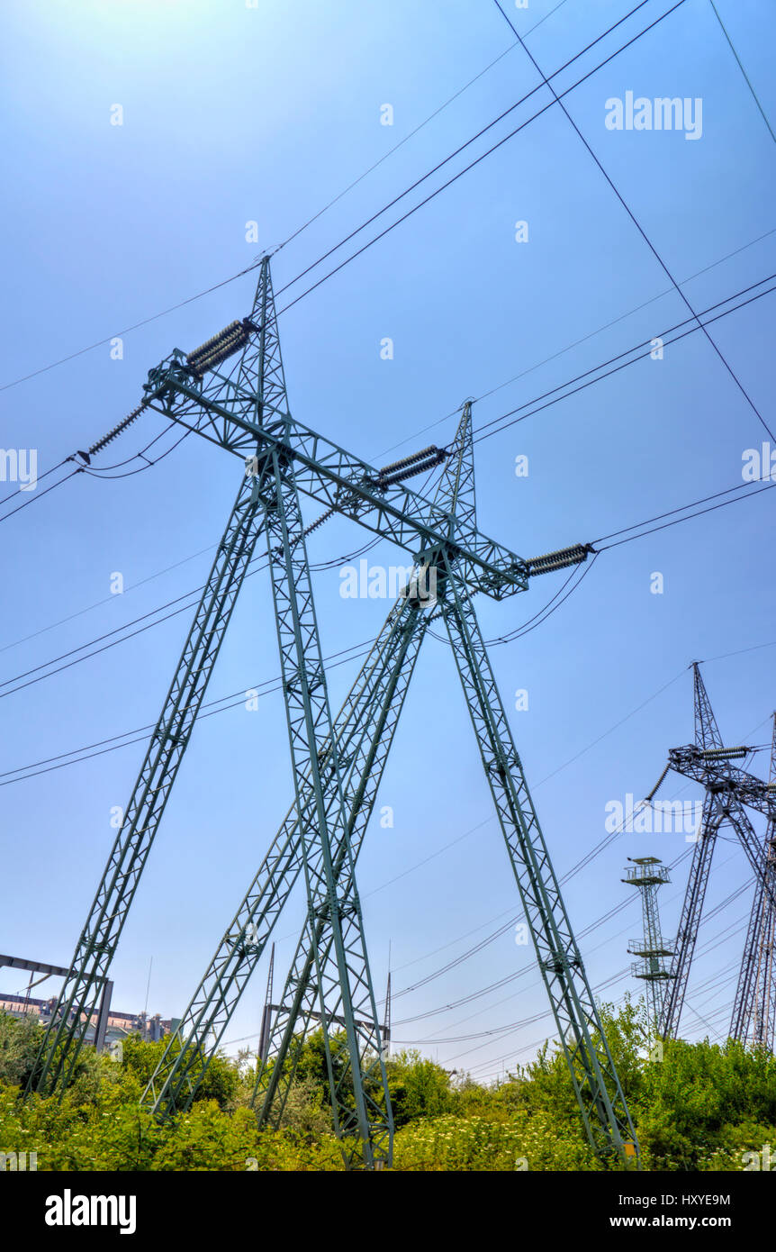 High voltage electrical overhead lines on blue sky Stock Photo - Alamy
