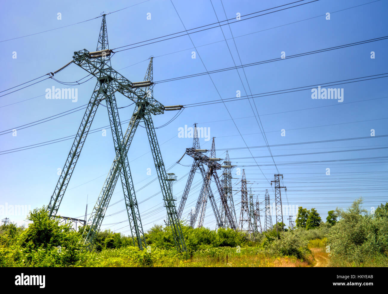 High voltage electrical overhead lines on blue sky Stock Photo - Alamy