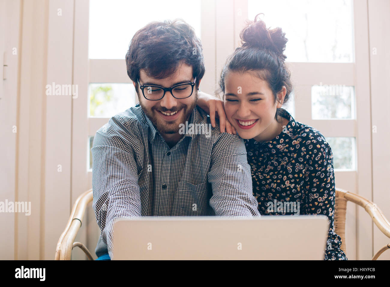 Young attractive couple having fun using a laptop indoors Stock Photo ...